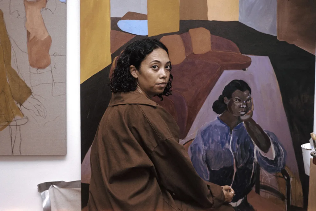 Artist Hana Ward in her studio in front of a painting in progress
